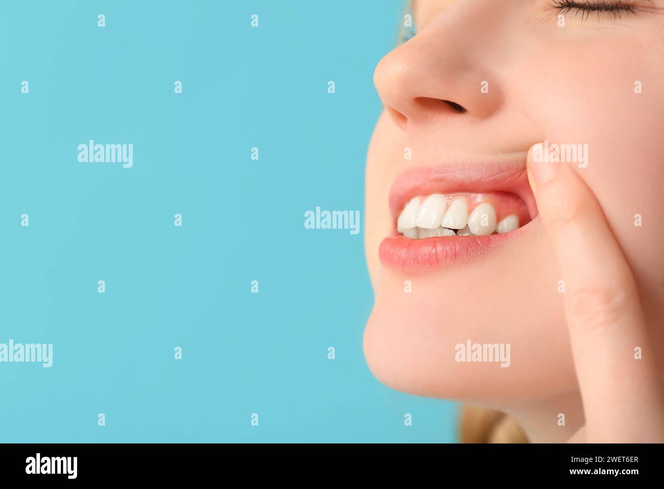 Teenage girl showing teeth on blue background, closeup Stock Photo - Alamy