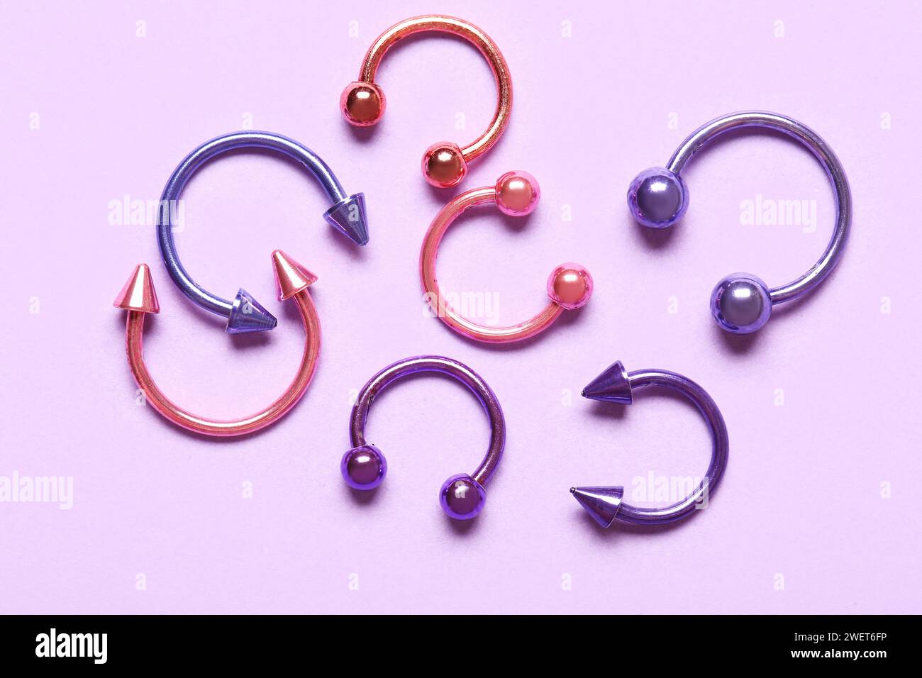 Colorful circular barbells for piercing on lilac background Stock Photo ...