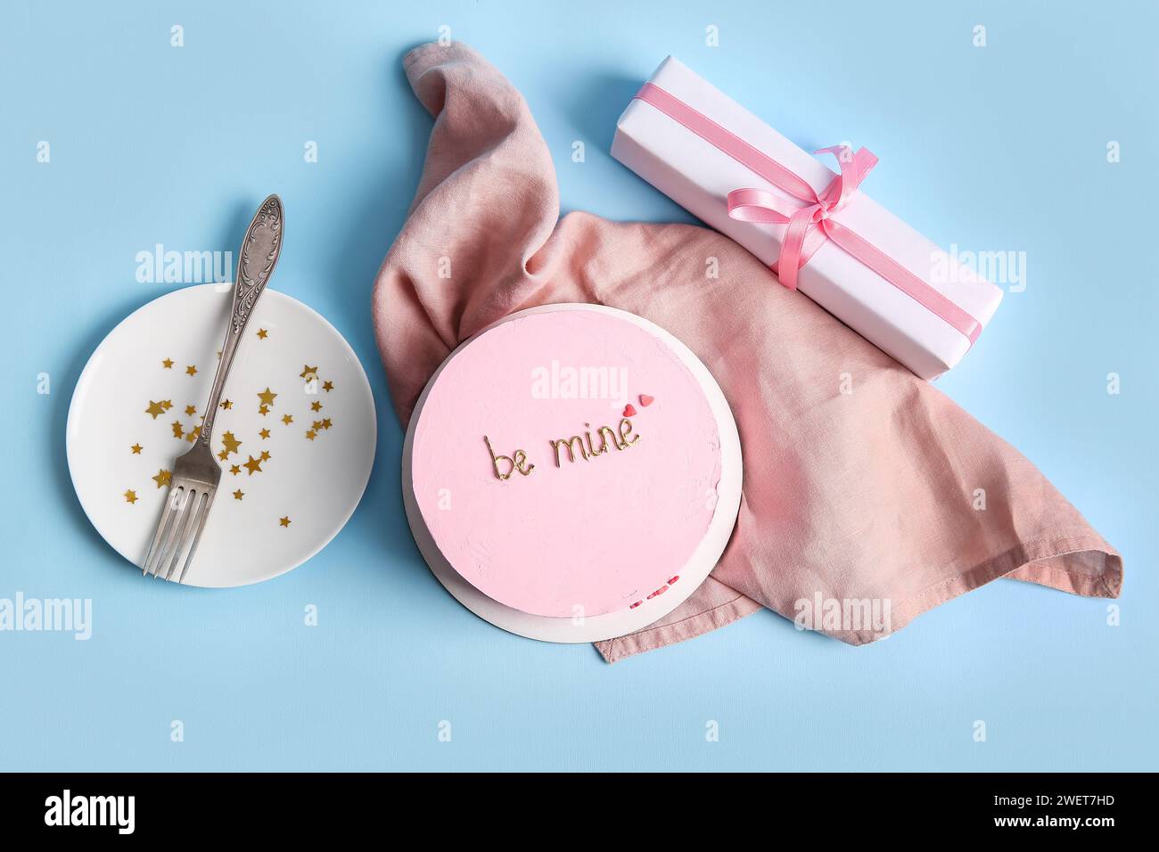 Pink bento cake with gift box and napkin on blue background. Valentine ...