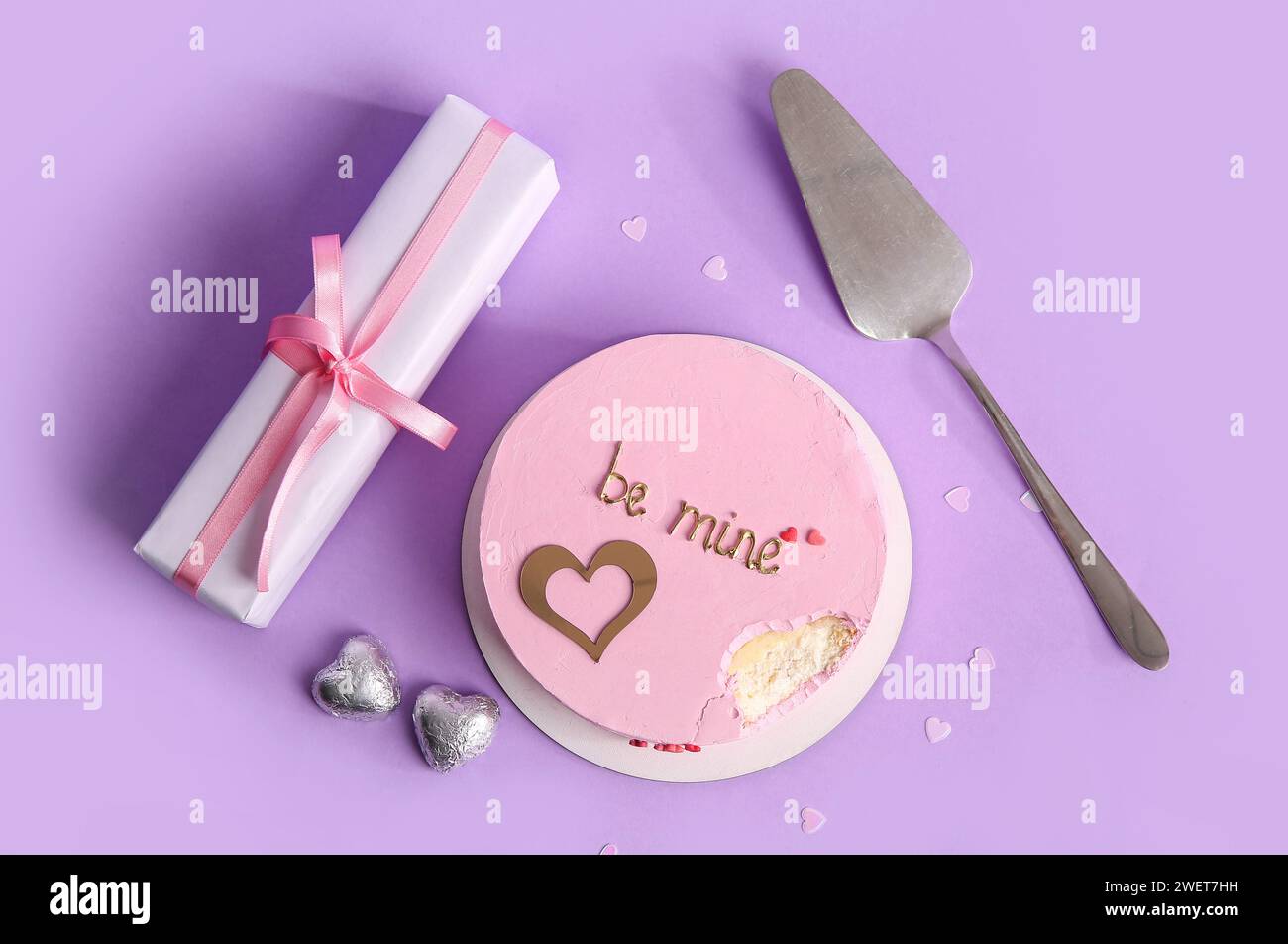 Bitten bento cake with gift box and spatula on purple background ...