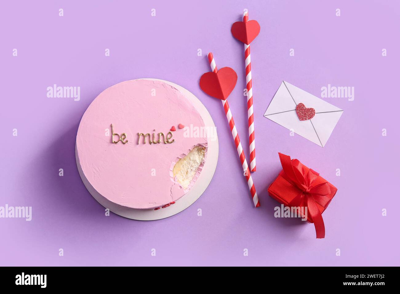 Bitten bento cake with gift box, straws and envelope on purple ...