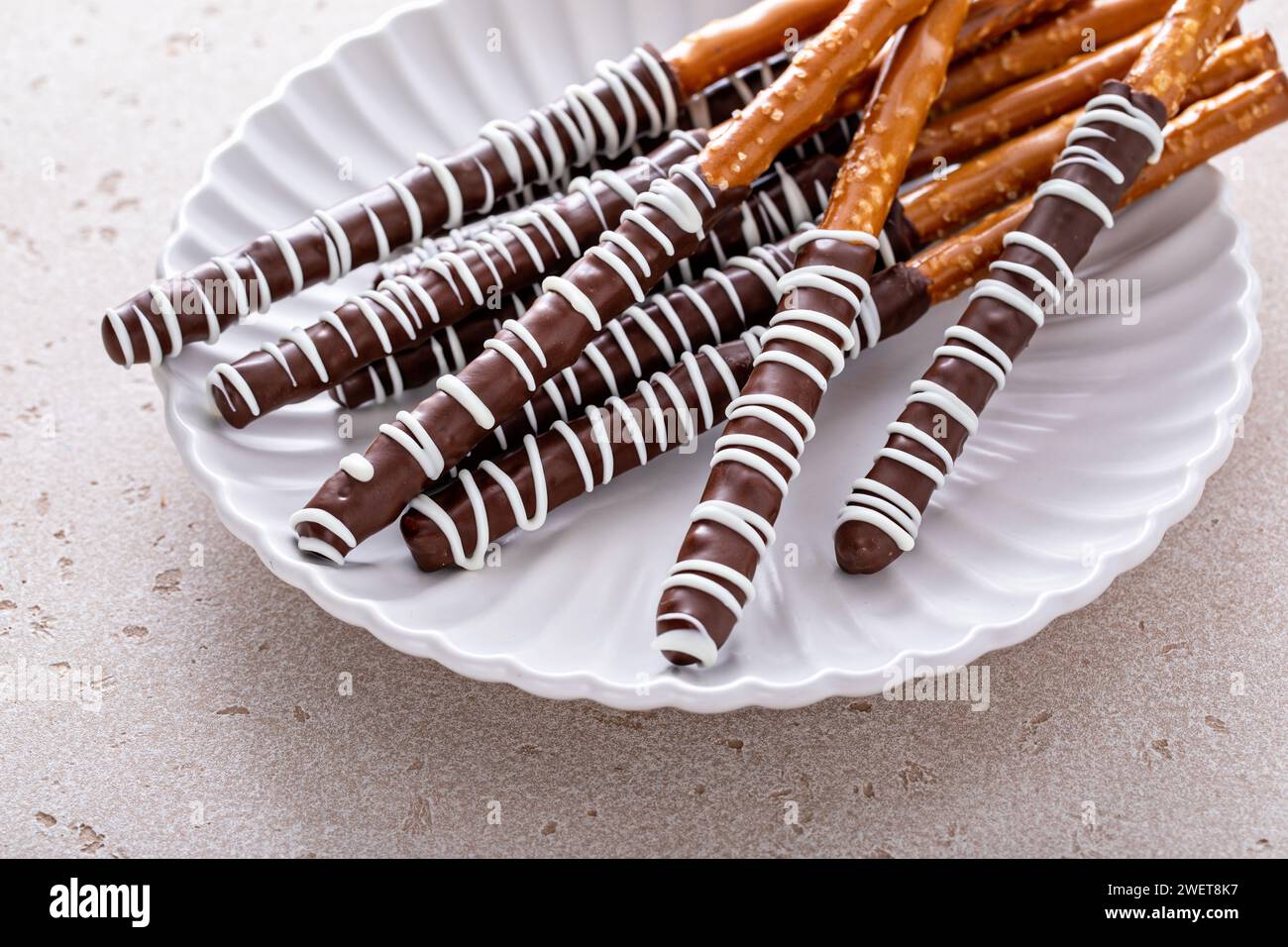 Chocolate dipped pretzel rods with dark and white chocolate on a plate ...