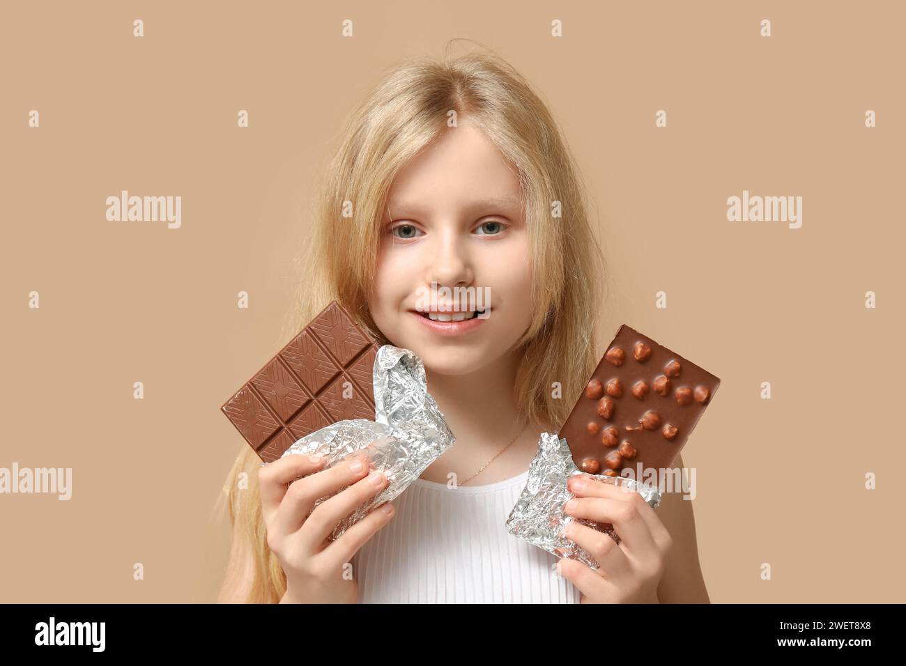 Cute little girl with sweet chocolate bars on brown background Stock ...
