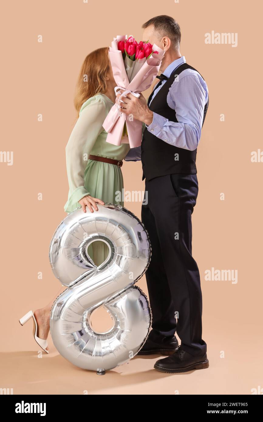 Middle-aged couple with bouquet and balloon in shape of figure 8 on ...