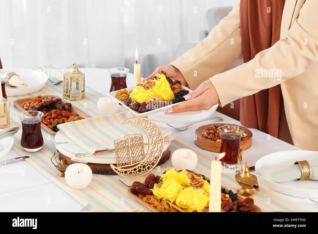 Mature Muslim woman setting table for dinner at home, closeup. Ramadan ...