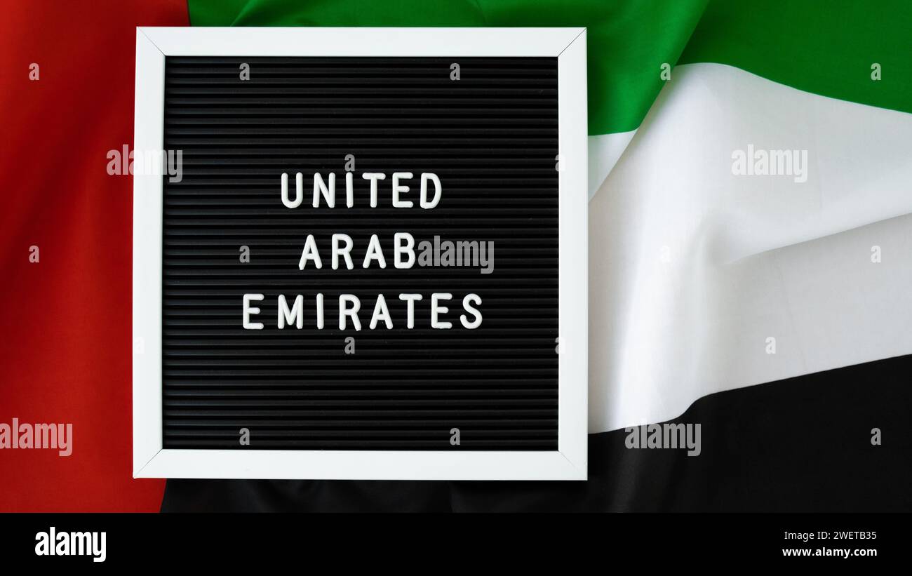 Message UNITED ARAB EMIRATES on background waving flag of UAE. National ...