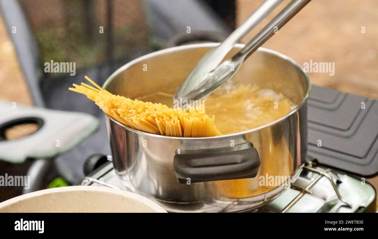 Cooking spaghetti outside in forest camping. Summer outdoors activities ...