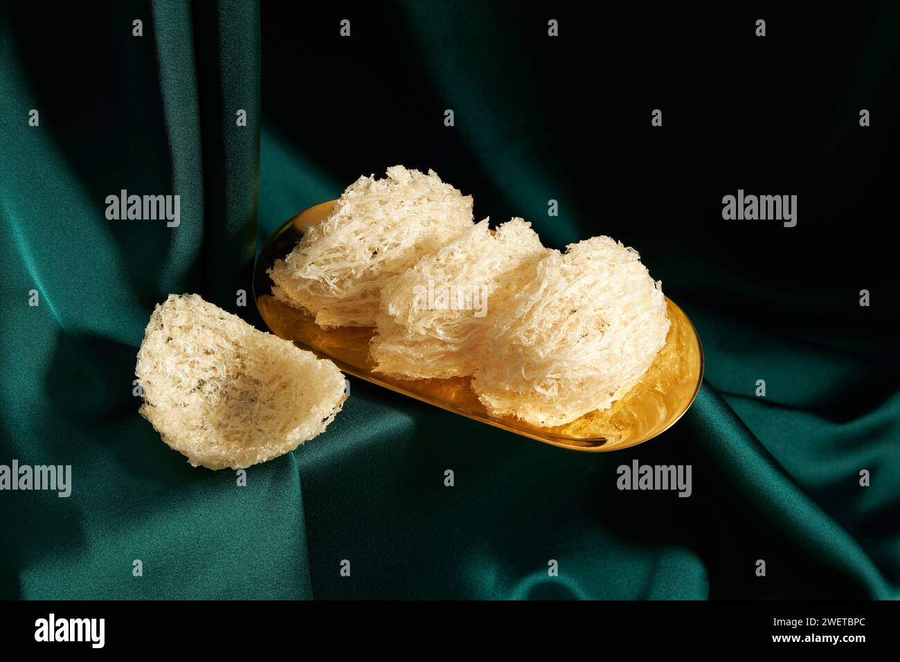 Raw bird nests are arranged on a long yellow tray, standing out against ...