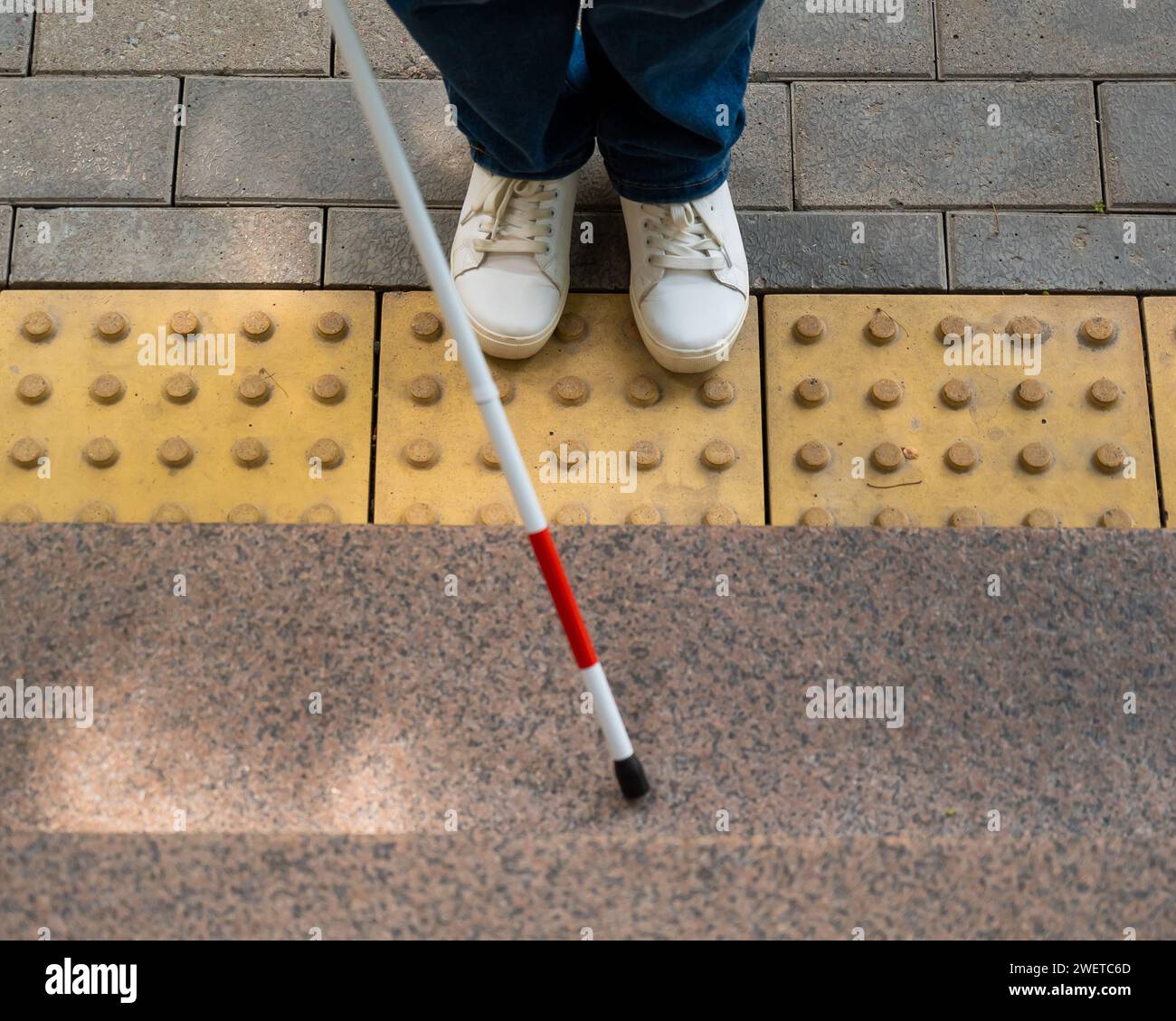 Blind woman walking outdoors using a tactile cane Stock Photo - Alamy