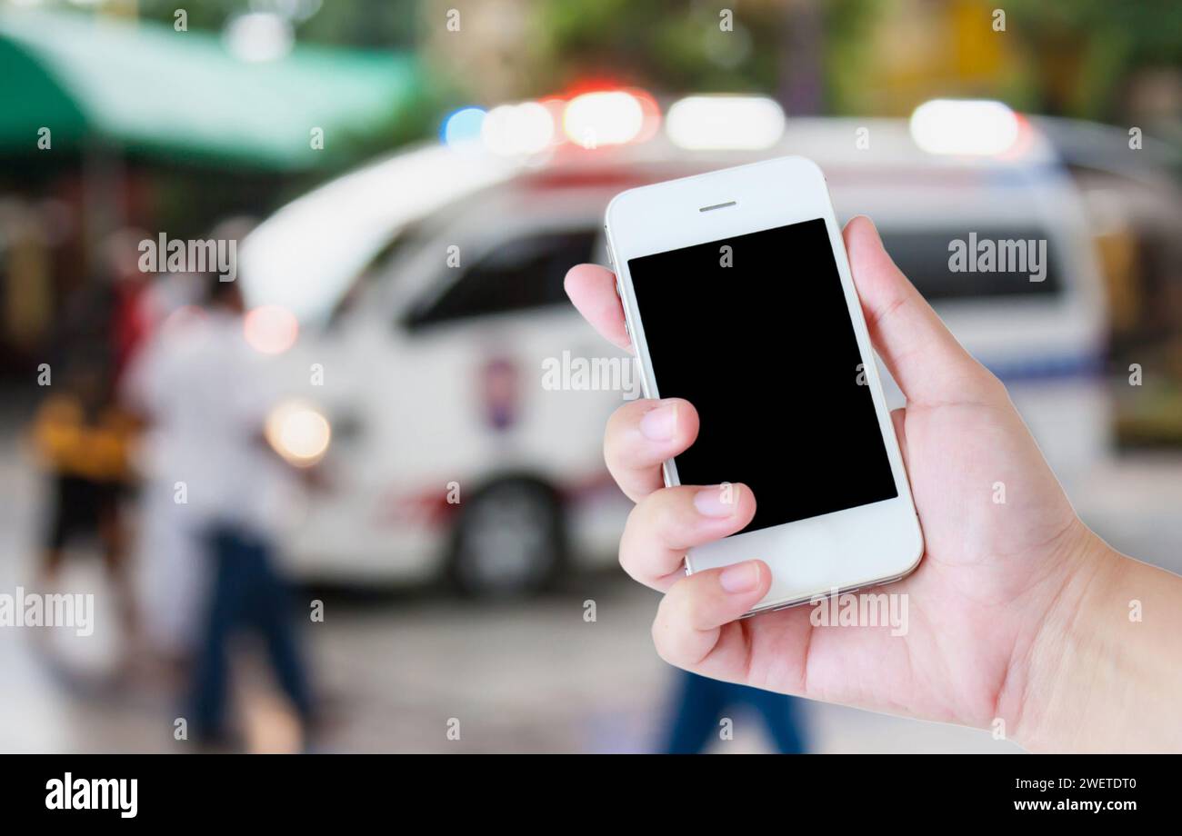 hand hold smartphone with Ambulance responding to an emergency call ...