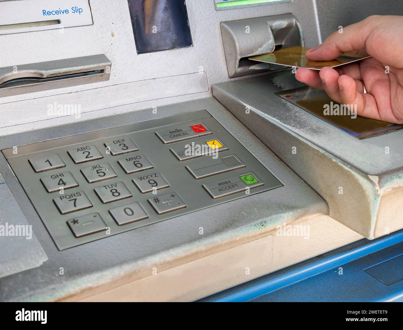female hand inserting ATM card into ATM bank machine to withdraw money ...