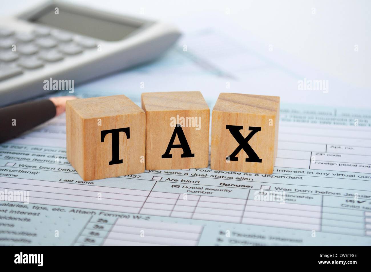 Tax wordings on wooden cubes with tax form and calculator background ...