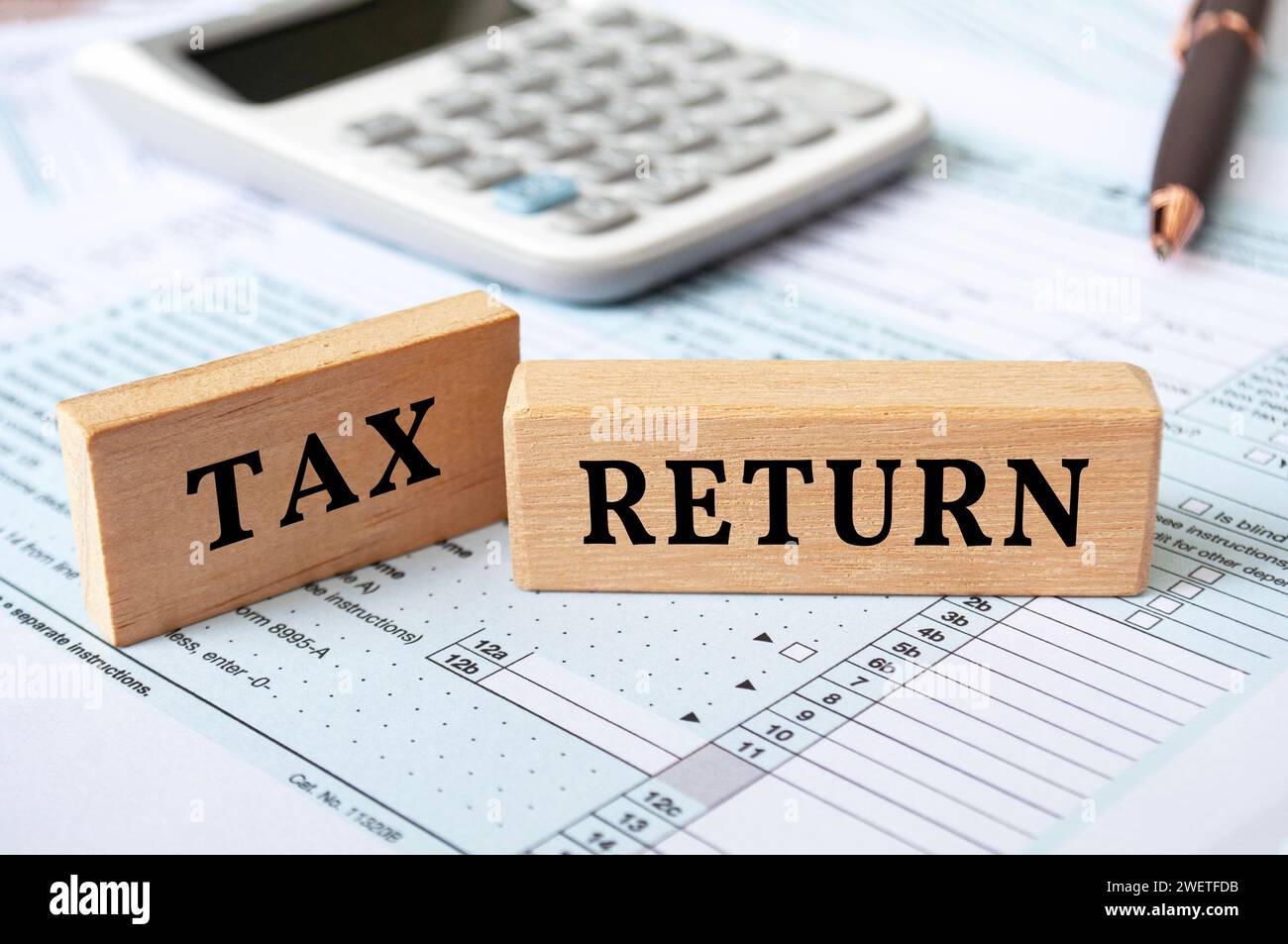 Tax return text on wooden blocks with tax form and calculator ...