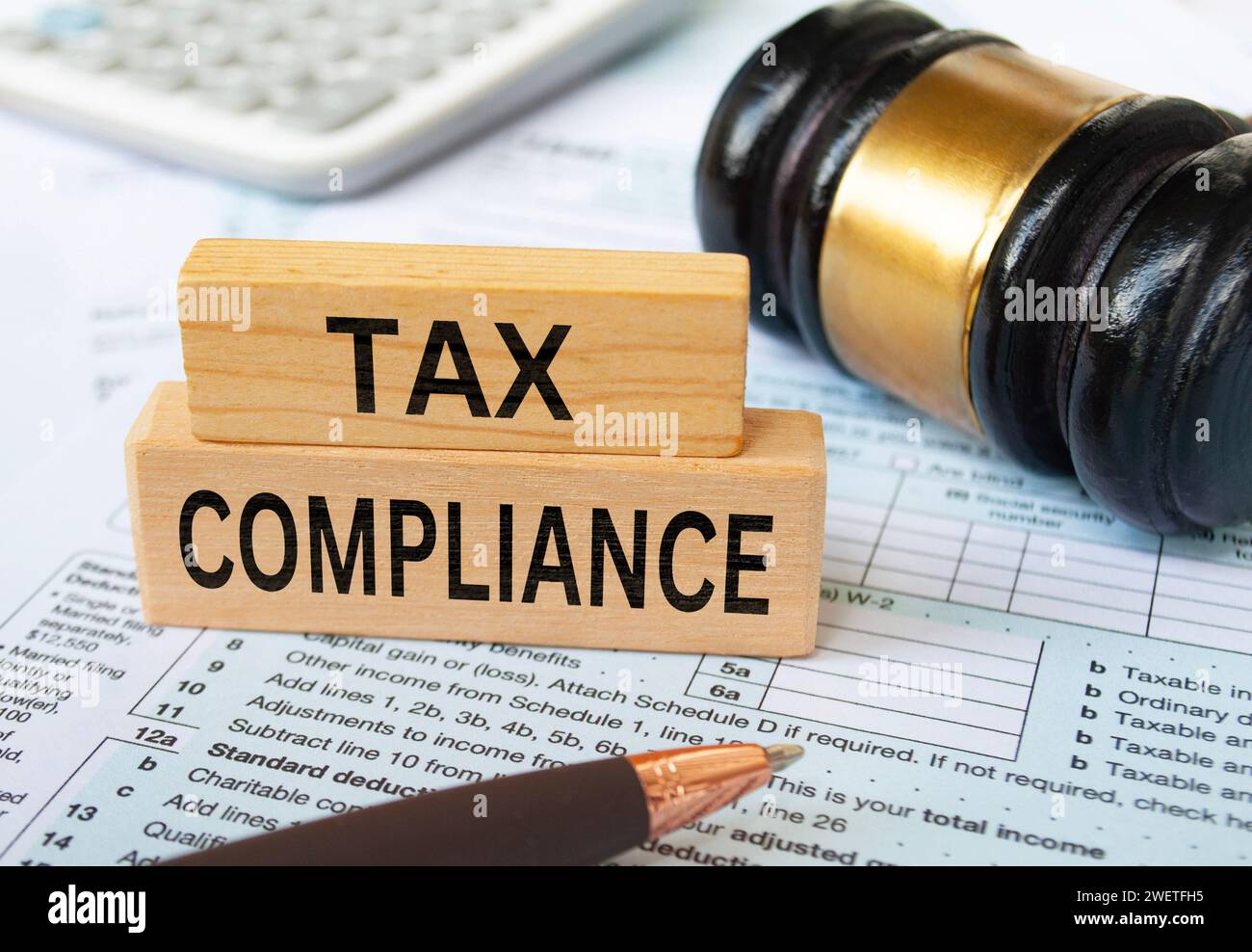 Tax compliance text on wooden blocks with tax form, gavel and ...
