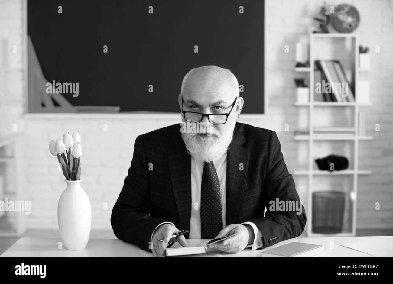 Elderly Senior professor reading an old book in the library, knowledge ...