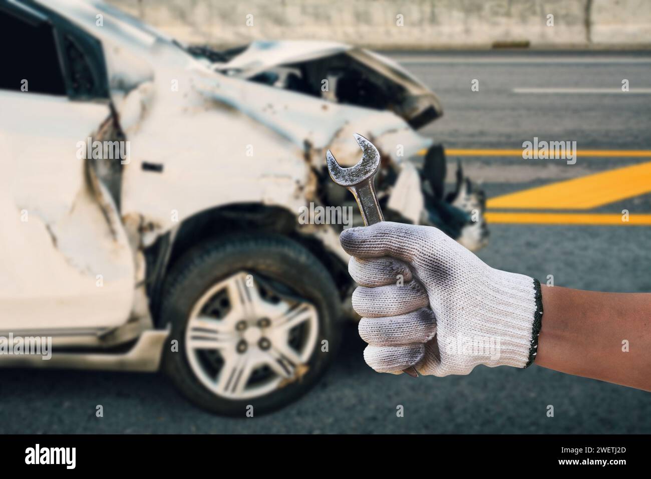 mechanic hand hold wrench with car crash accident damage background ...