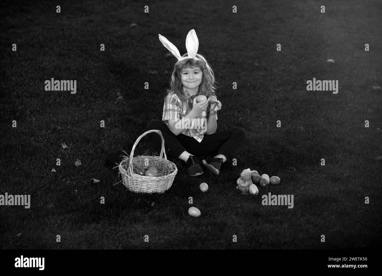 Bunny kids with rabbit bunny ears. Easter egg hunt in garden. Child boy ...