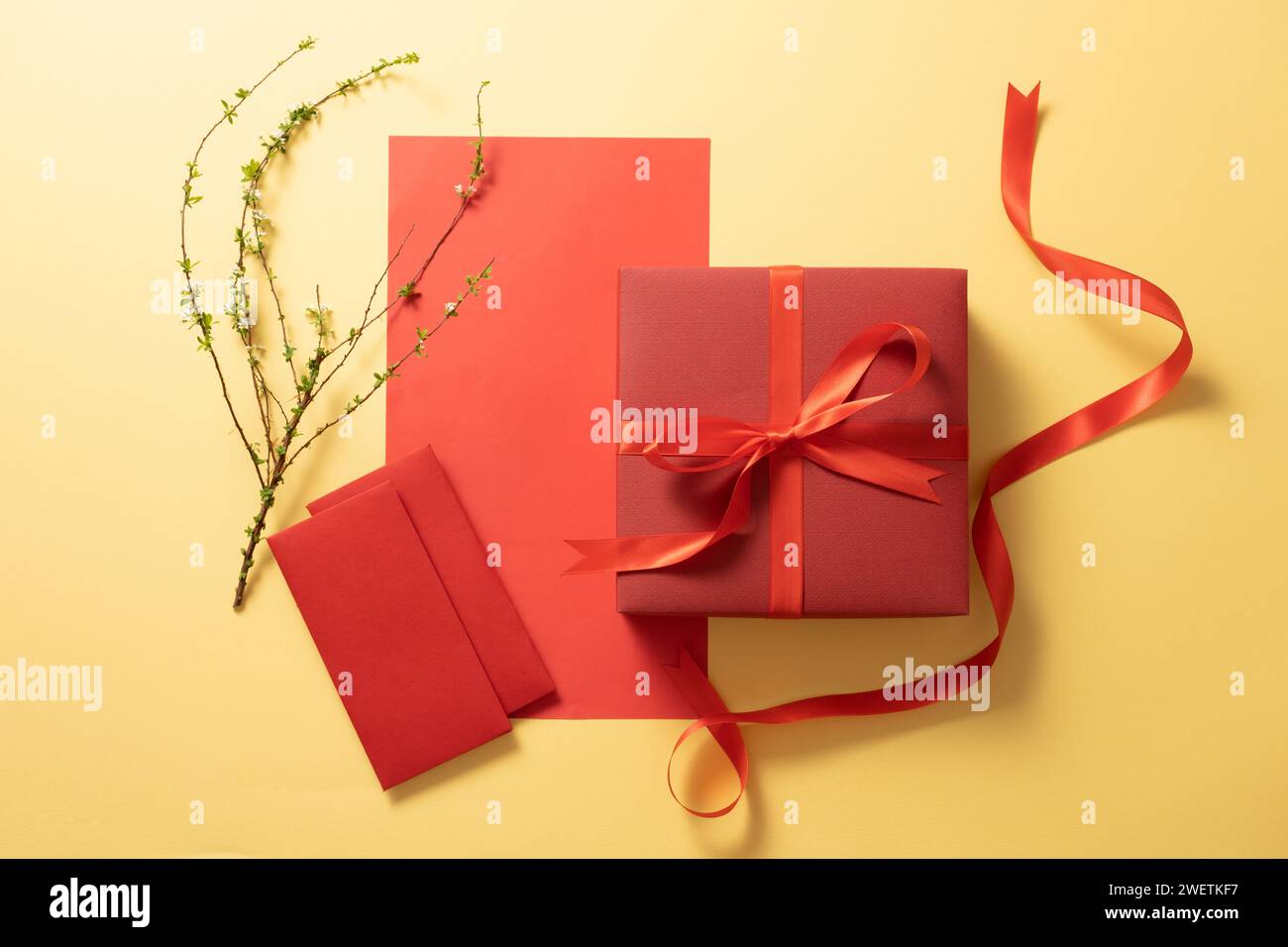 Red paper envelopes, pretty red gift boxes and small flower branch on ...