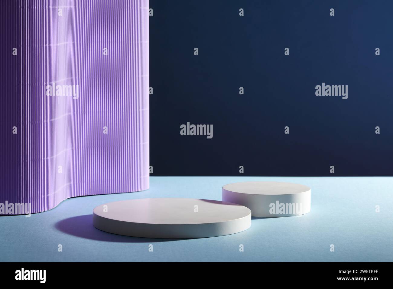 Front view of two round empty podiums on dark background. Purple paper ...
