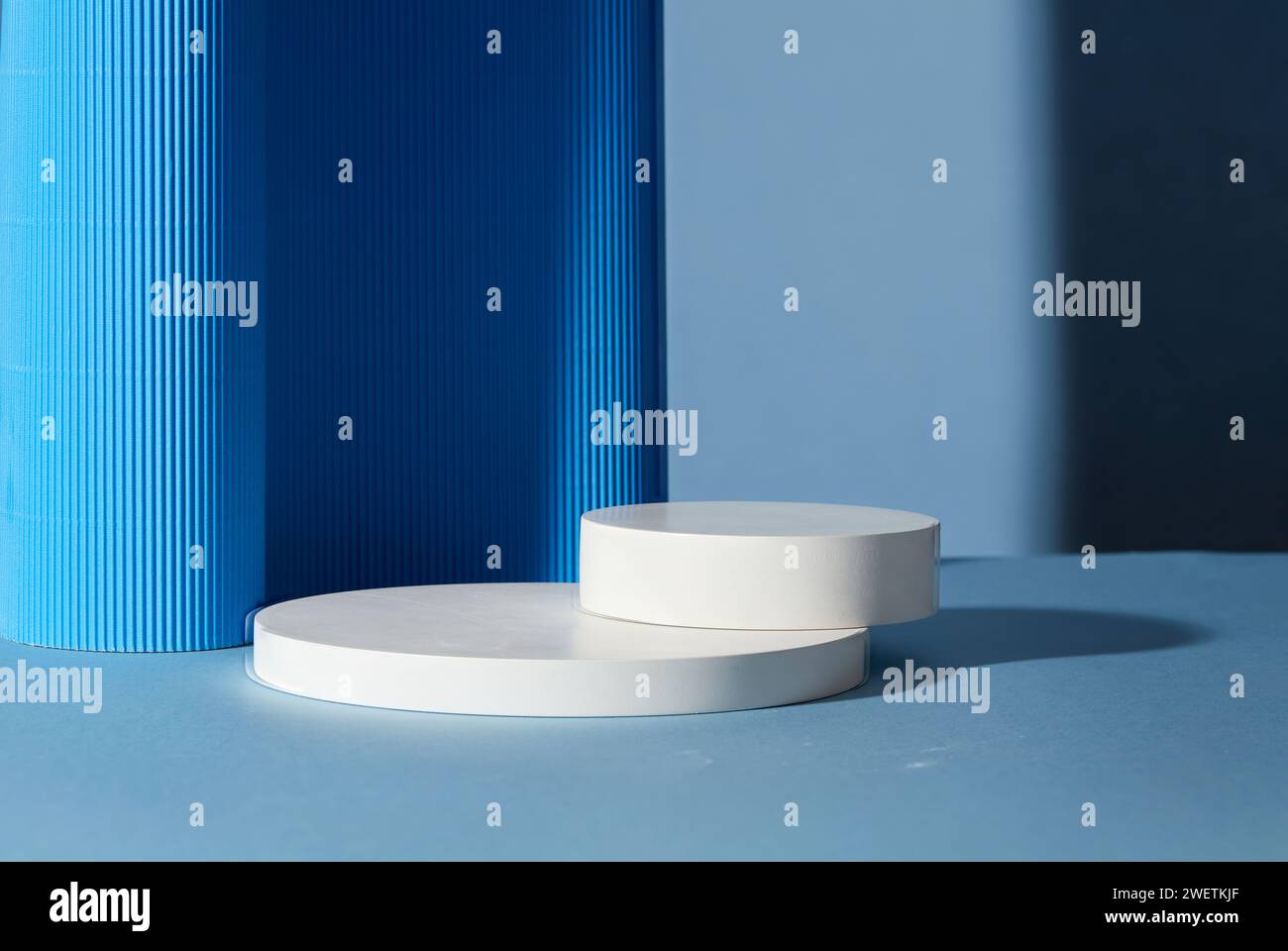 Two empty round white platforms stacked on top of each other, decorated ...