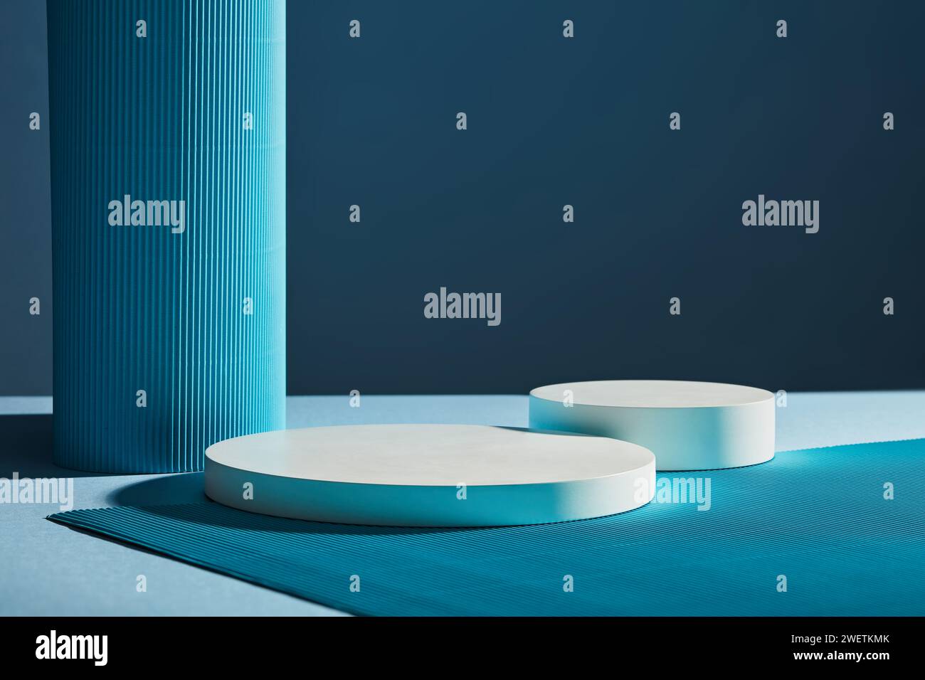 Front view of two white round empty podiums on dark blue background ...