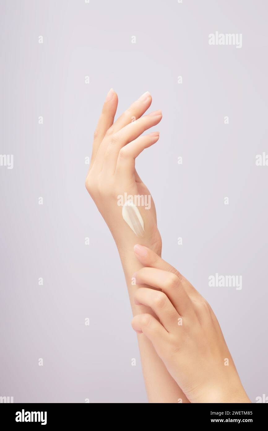 Beautiful woman's hand applying cream on back of hand, applying lotion ...