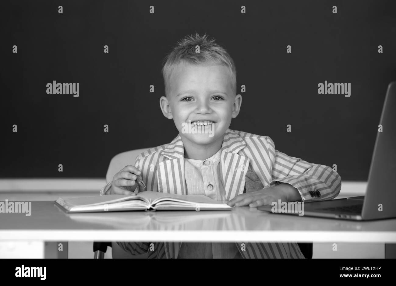 Kid writing in class. School child student learn lesson sitting at desk ...