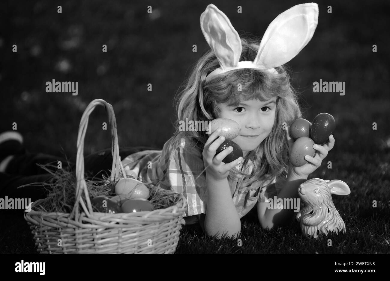 Child boy hunting easter eggs in spring lawn laying on grass. Child ...