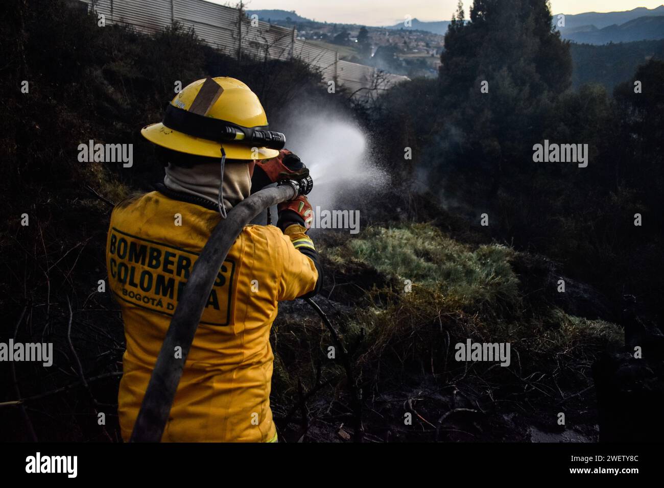 Bogota, Colombia. 25th Jan, 2024. Firefighters work to extinguish the ...