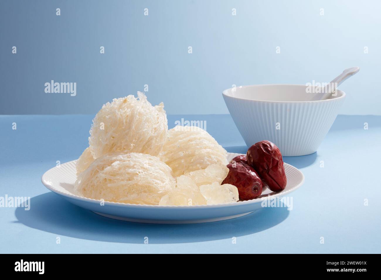 Front view of raw bird’s nest, rock sugar and jujube on round plate ...