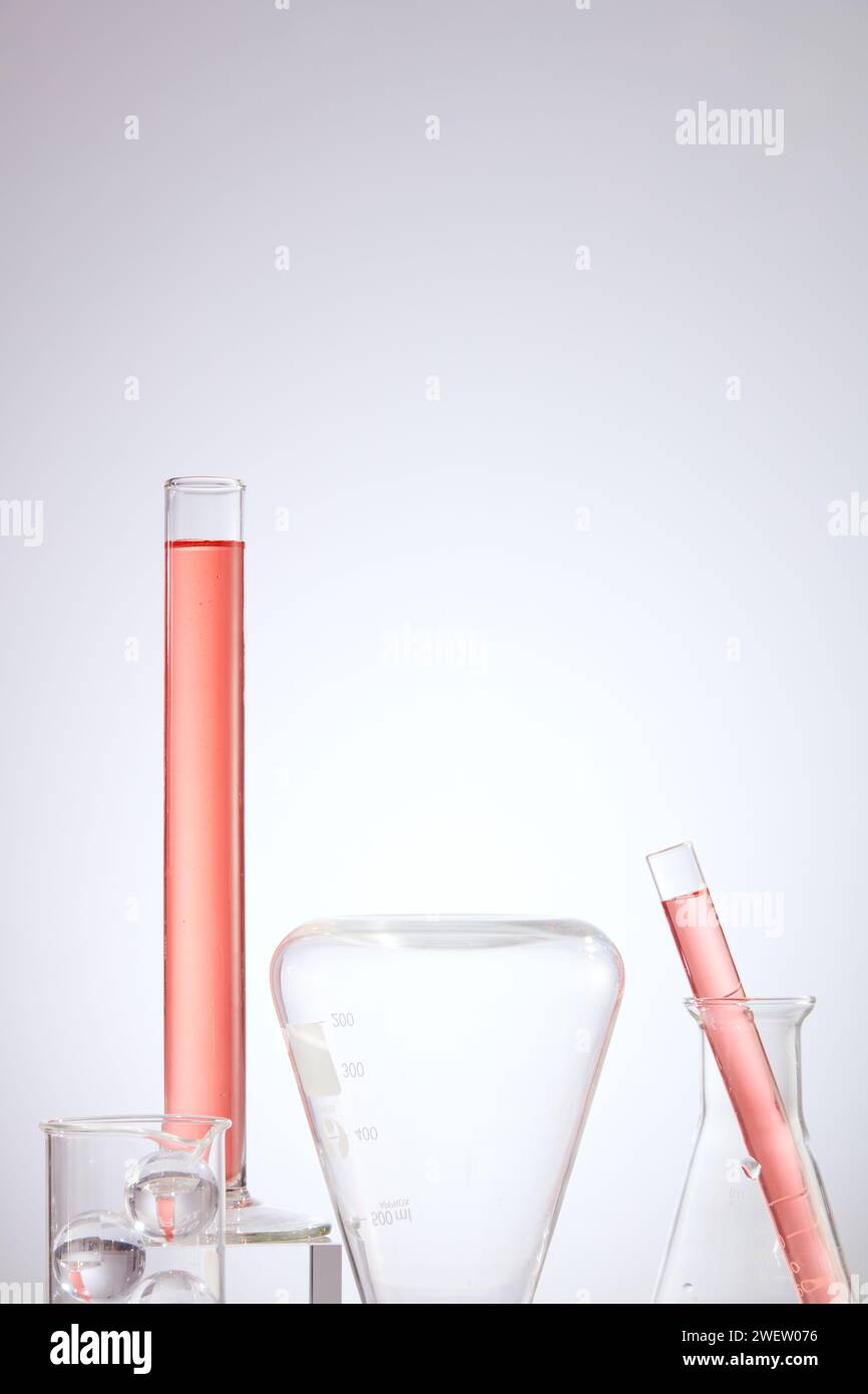 Laboratory concept with lab glassware containing pink liquid on light ...