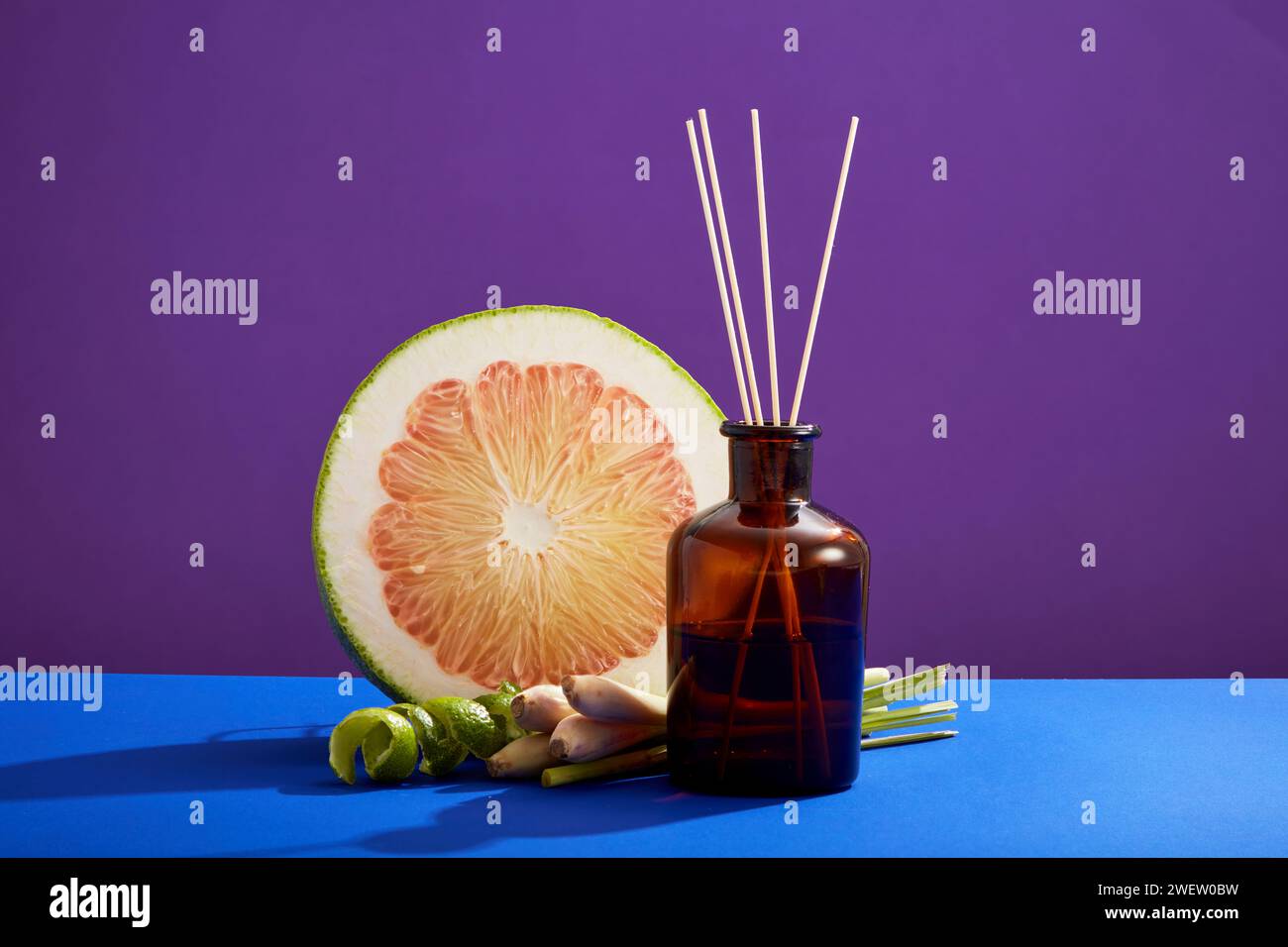 Top view of empty glass bottle, reed diffuser, fresh lemongrass and cut ...