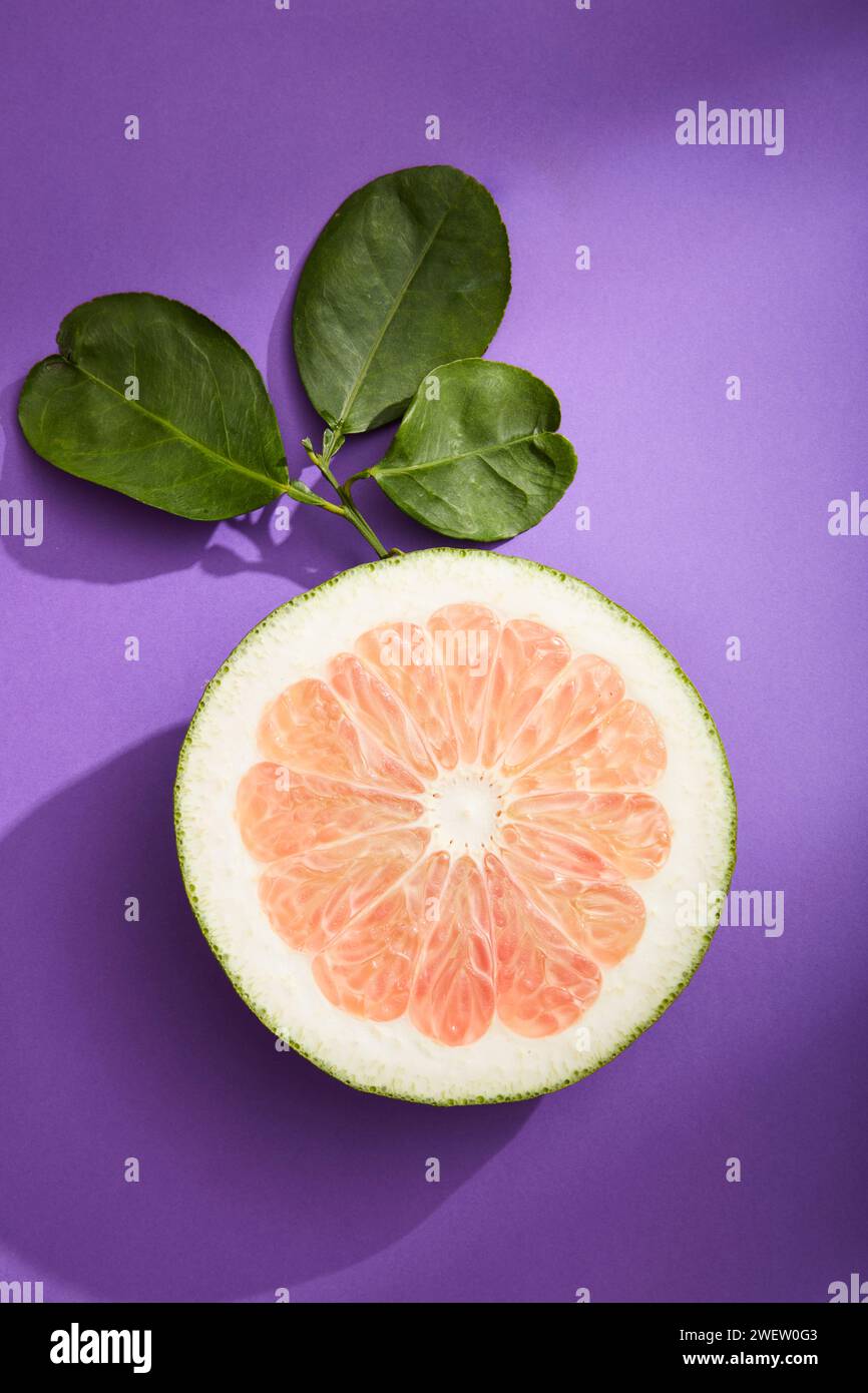 Top view, flat lay of fresh pink pomelo slice and green pomelo leaves ...