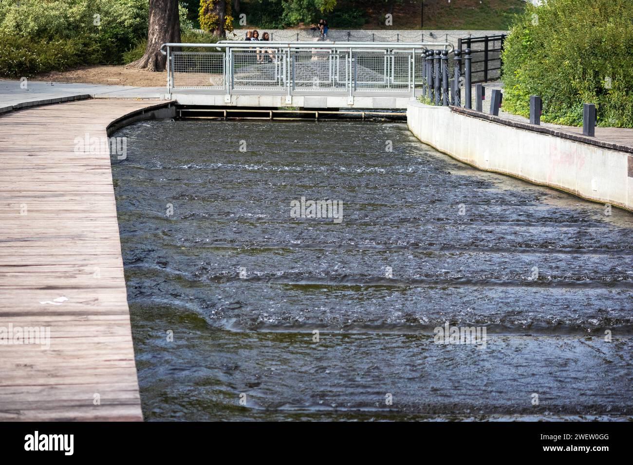 A water channel with a metal pedestrian bridge across the channel Stock ...