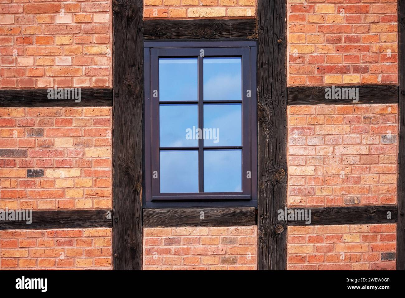 A window in the frame wall of a red brick and wooden building Stock ...