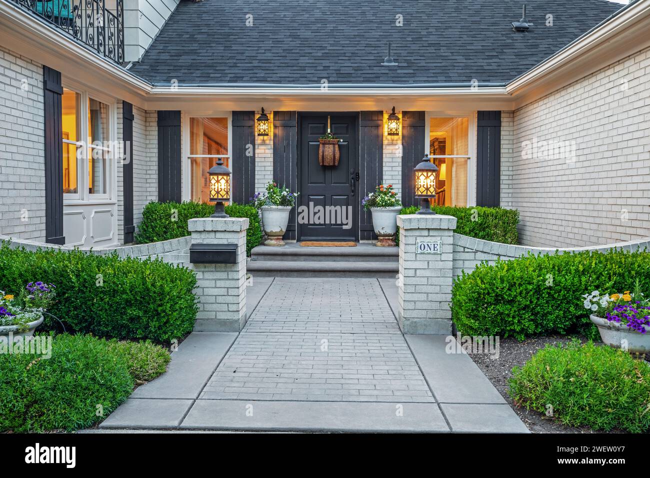 Two-level house with dual front porches adorned with potted flowers ...