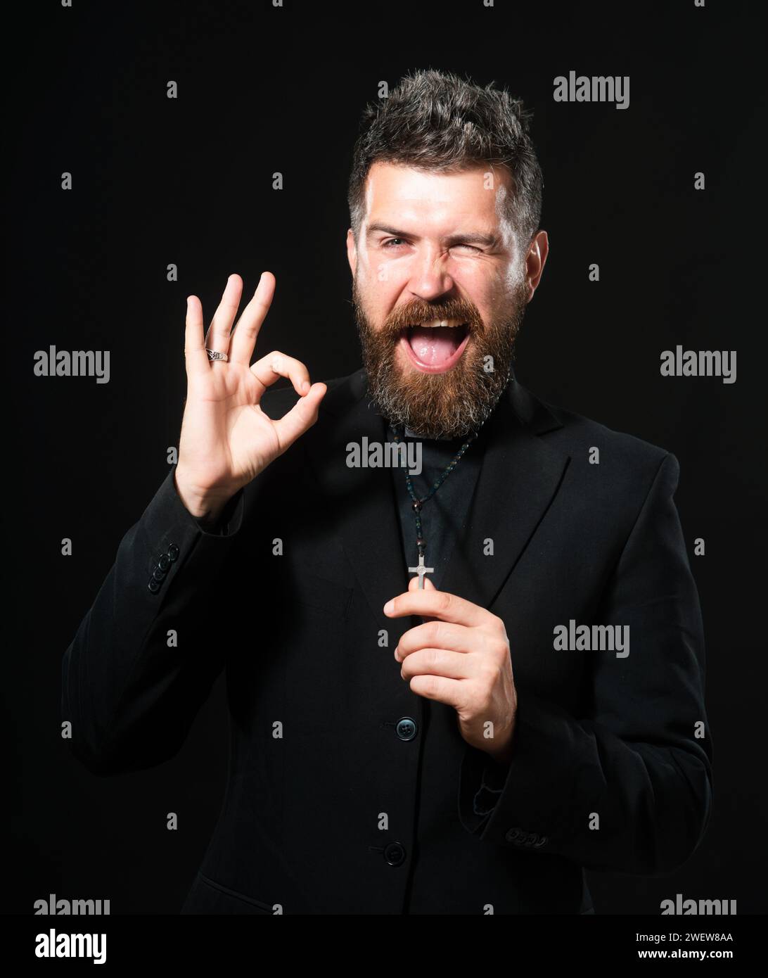 Young man wearing priest uniform standing over white background doing ...