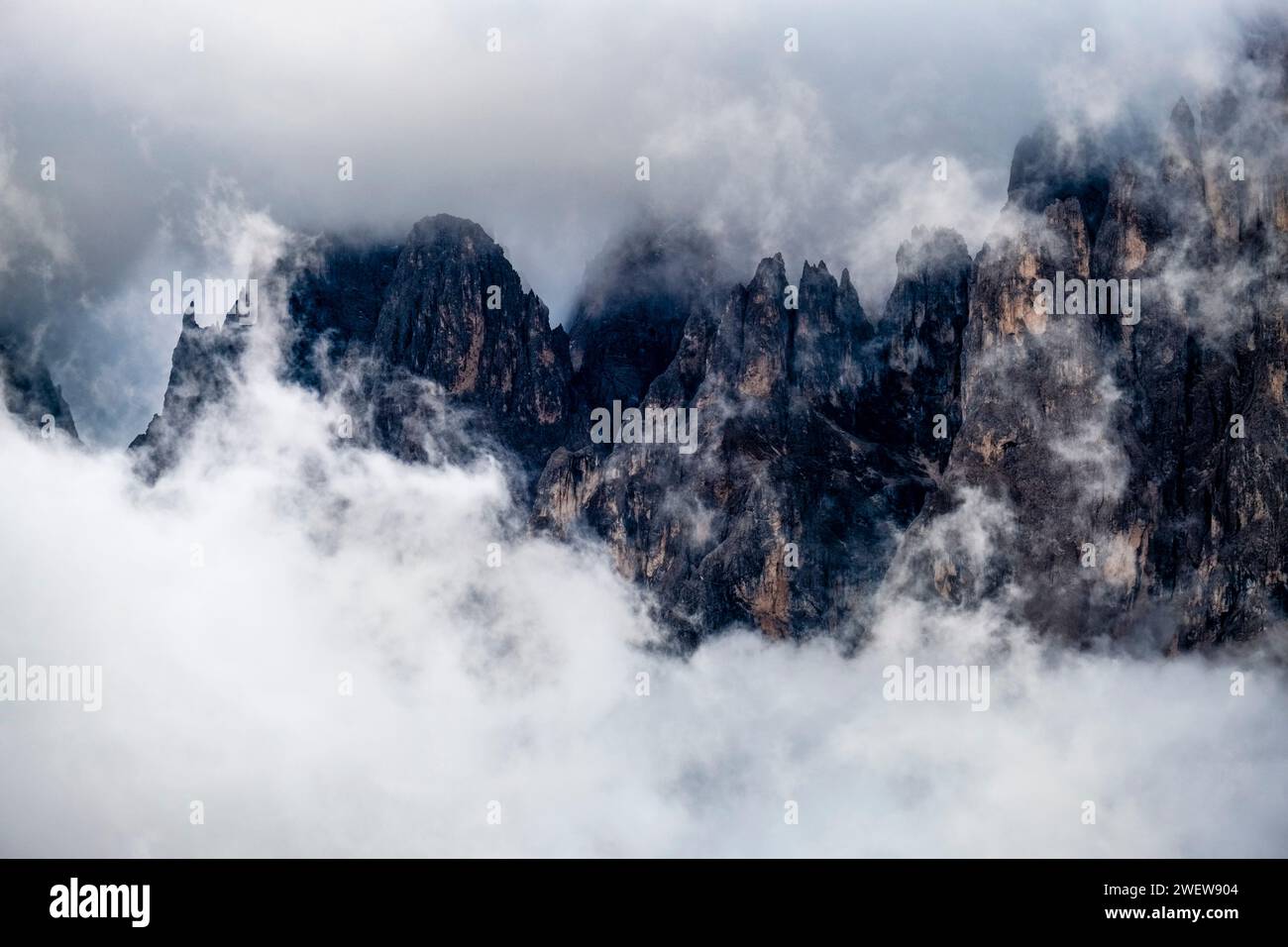 Rising clouds after a rain shower surrounding the rock cliffs around ...