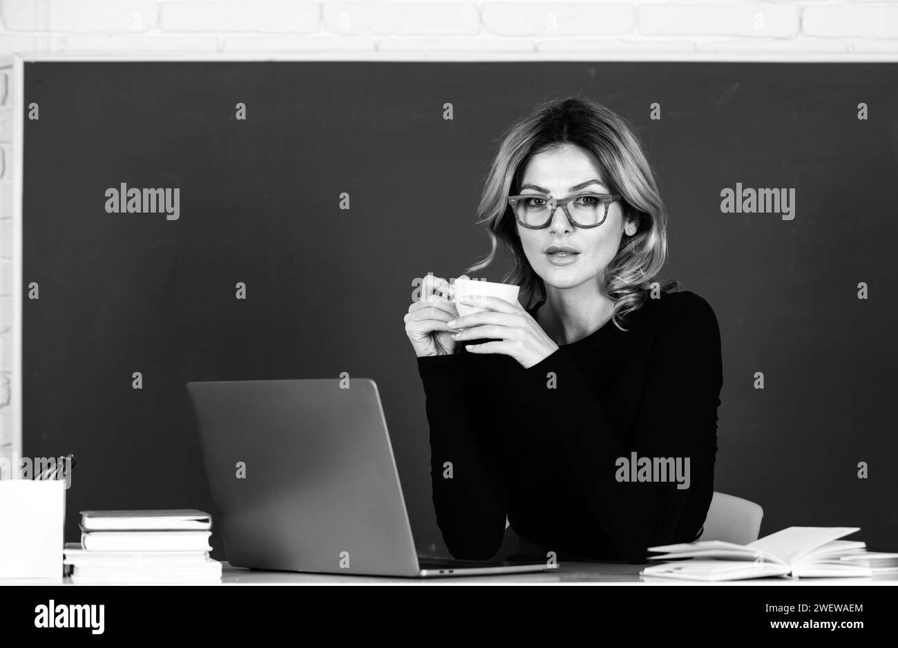 Portrait of female teacher teaching drinking coffee in classroom on ...