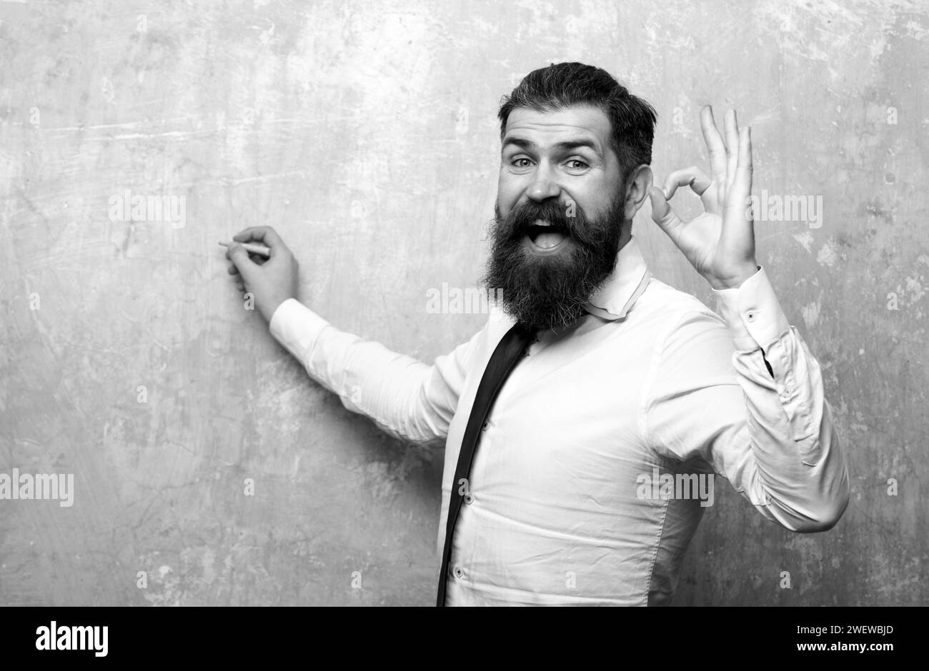 Happy smiling business man draw on wall. Businessman writing with ...