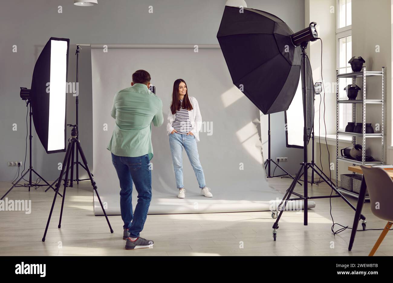 Beautiful model posing for male photographer in studio Stock Photo - Alamy