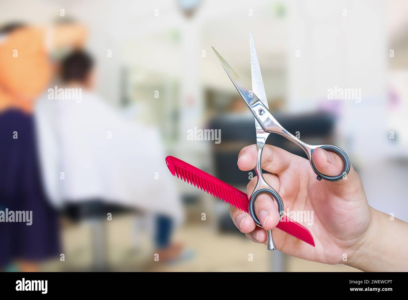 Hairdresser's hand hold scissors with salon beauty interior blur ...
