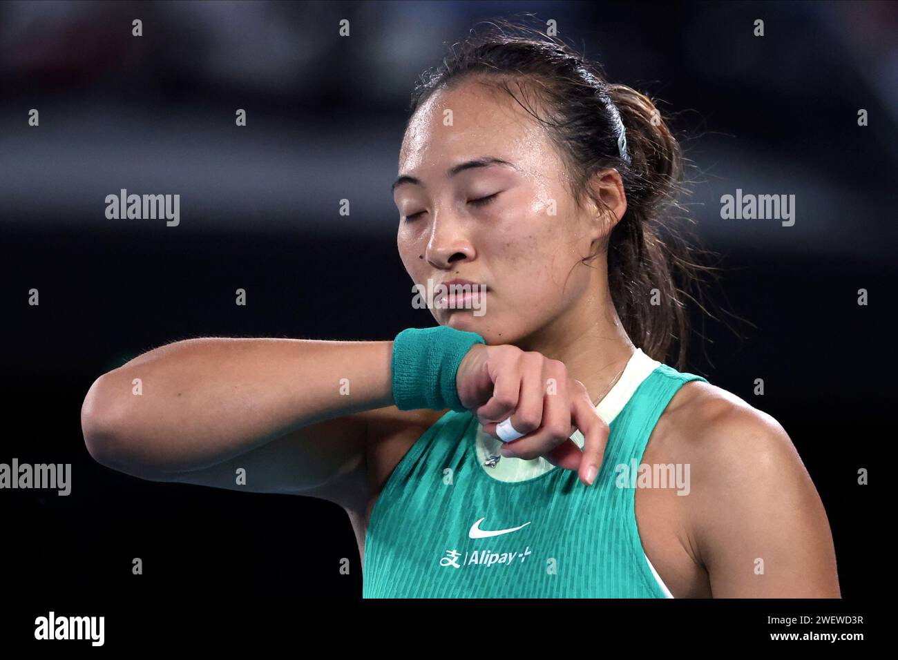 Zheng Qinwen of China wipes sweat from her face duirng her match ...