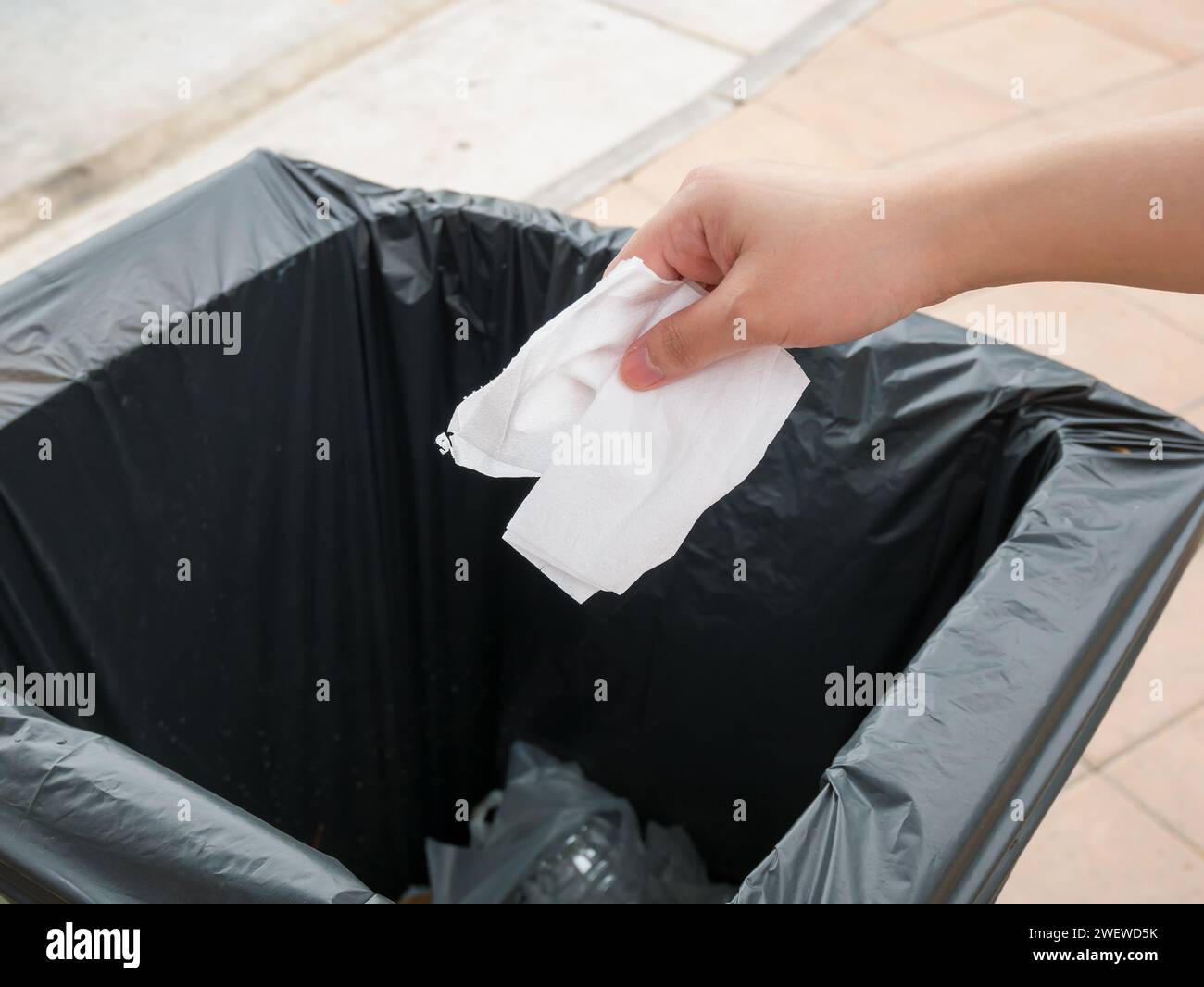 hand putting paper into trash bin Stock Photo - Alamy