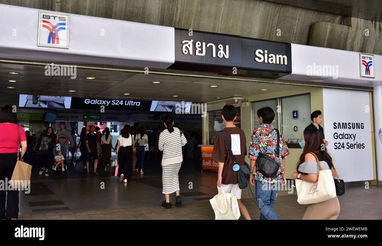 People at entrance to Siam BTS skytrain station next to Siam Mall or ...