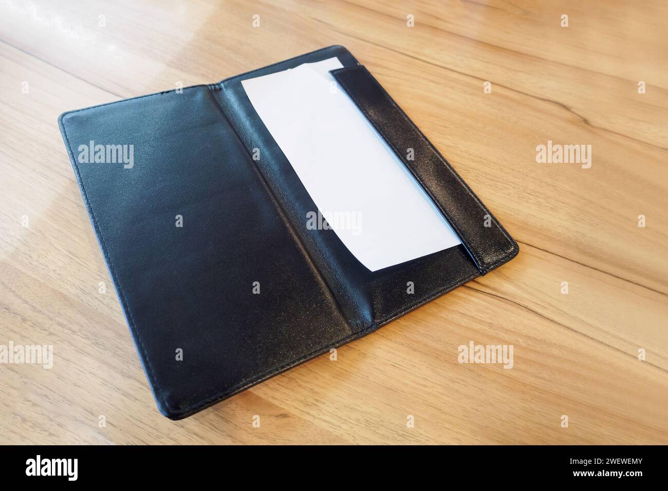 Blank empty white paper in black leather restaurant payment billing ...