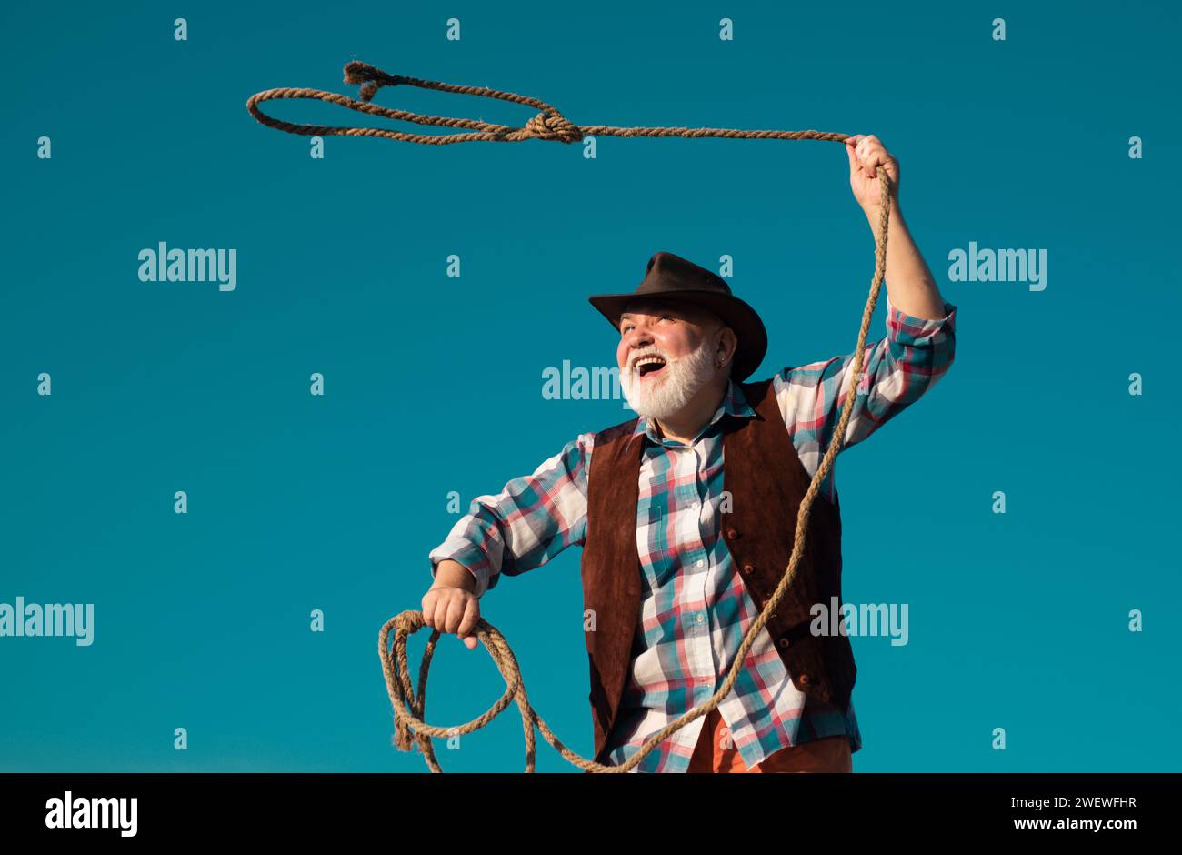 Old wild west cowboy with rope. Bearded western man throwing lasso with ...