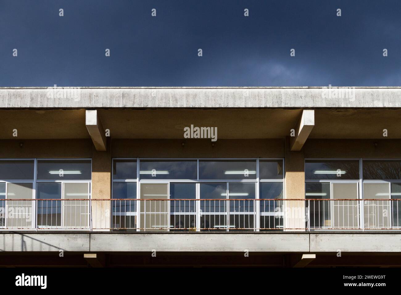 Windows and balconies on a flat-roofed old school building under a ...