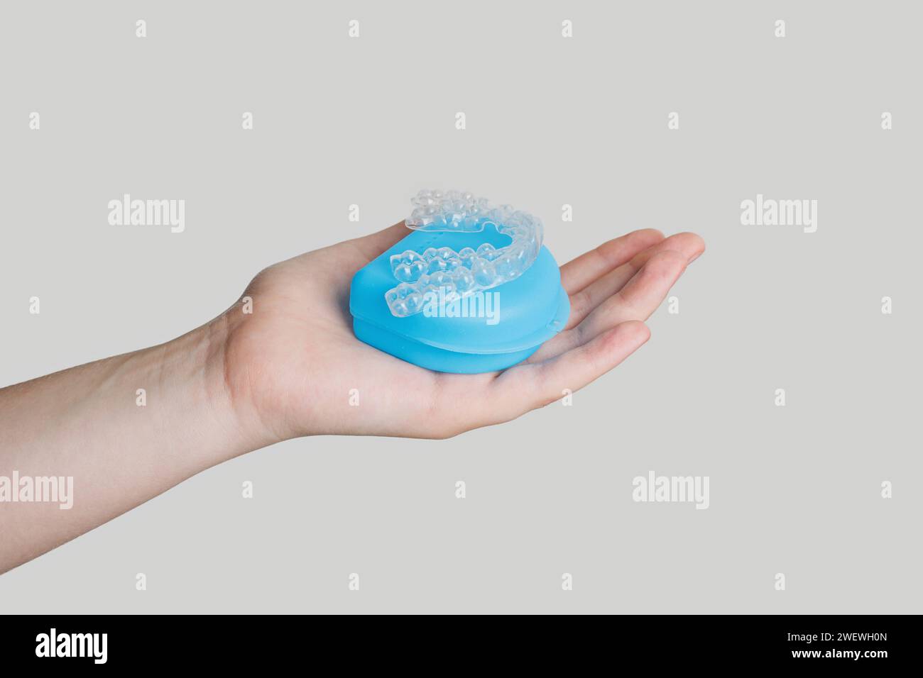 Human hand holds invisible aligners plastic braces dentistry retainers ...