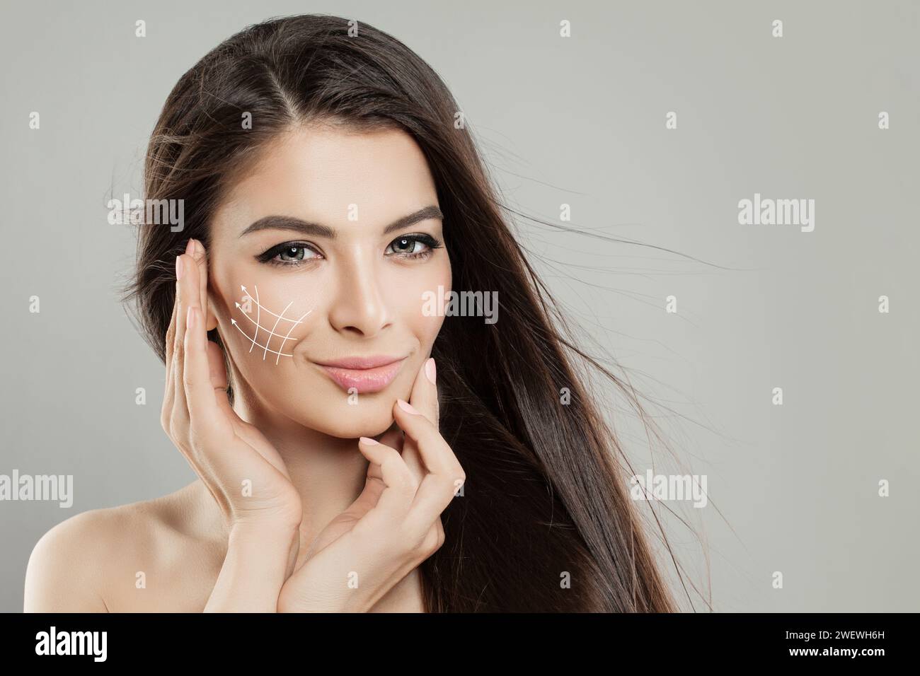 Close-up of attractive young female model with light lines on her face ...